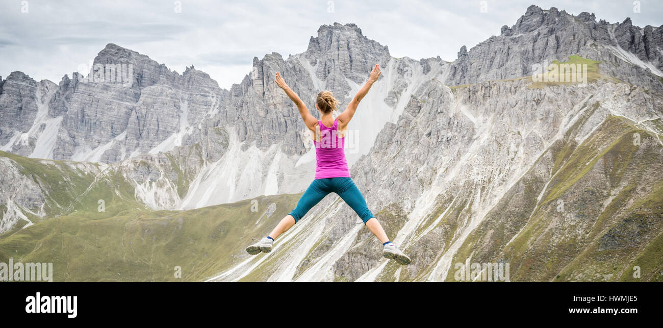 young woman jumping on top of the mountain Stock Photo - Alamy