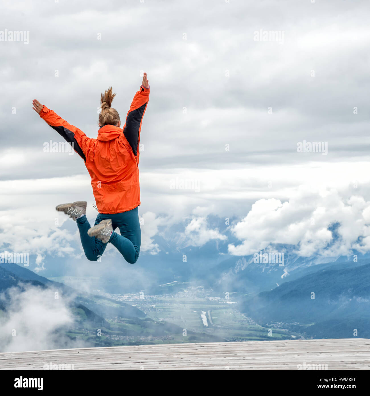 young woman jumping on top of the mountain Stock Photo - Alamy