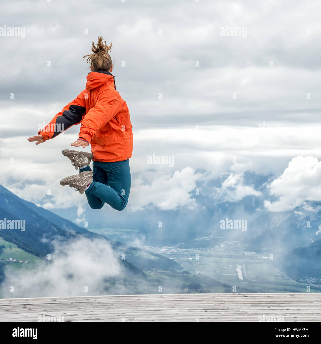 young woman jumping on top of the mountain Stock Photo - Alamy