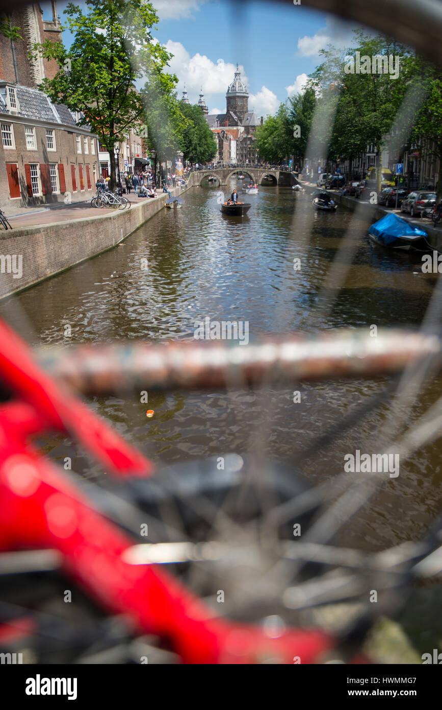 Amsterdam canal seen through bike wheel Stock Photo - Alamy