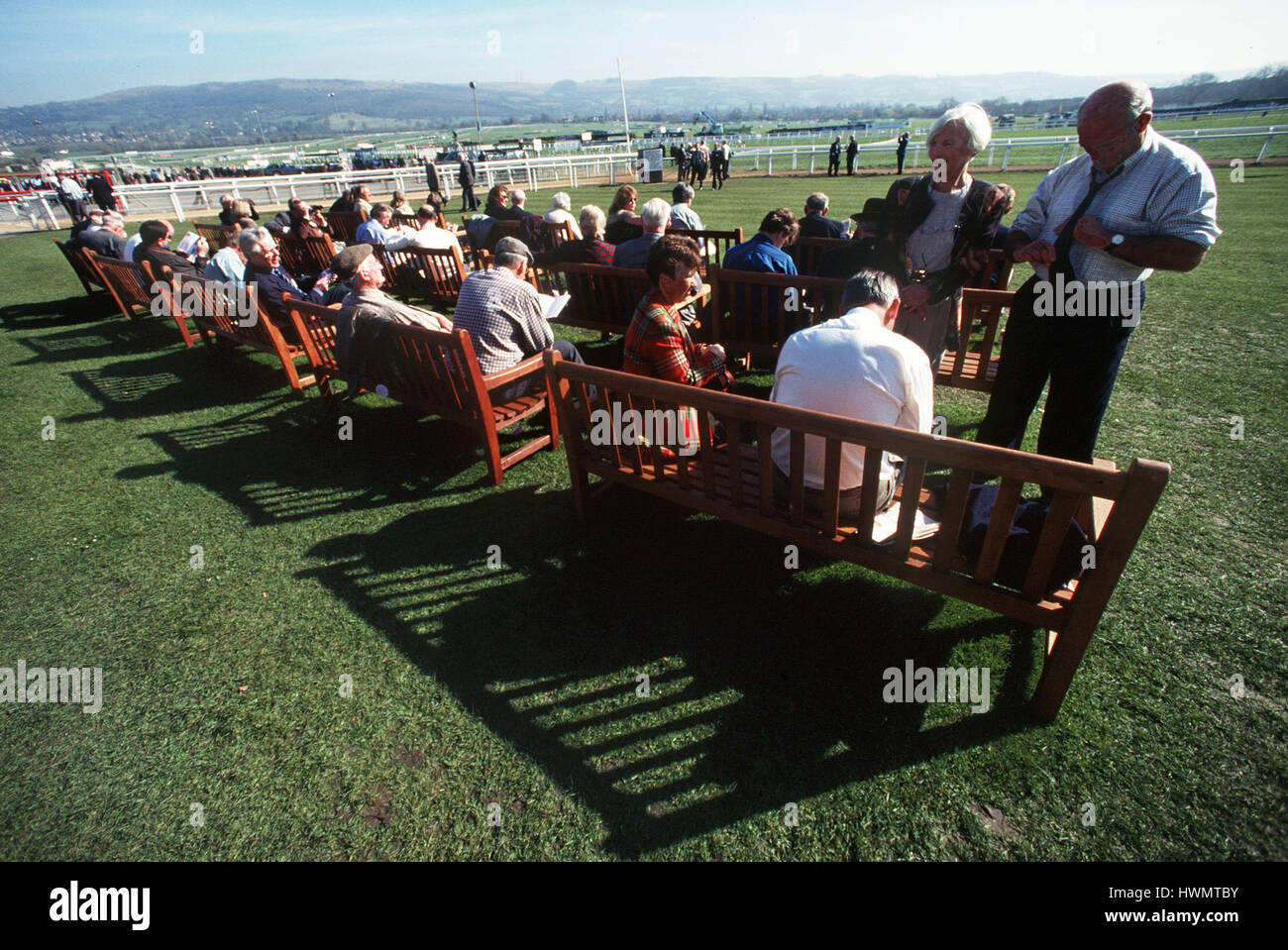 RACEGOERS ON BENCHES CHELTENHAM FESTIVAL 1999 18 March 2000 Stock Photo ...