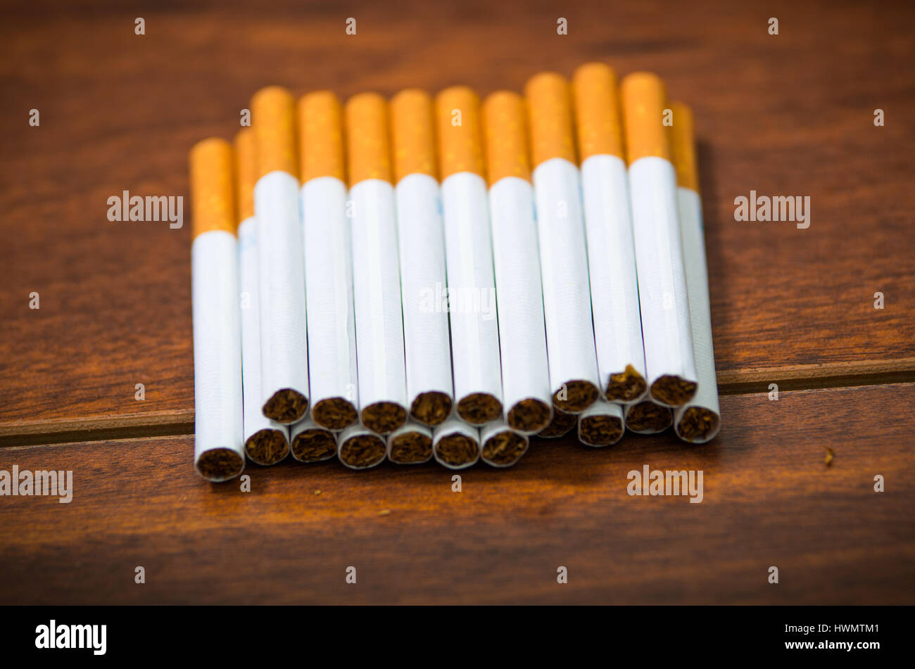 Stack of many cigarettes placed on wooden surface, as seen from above ...