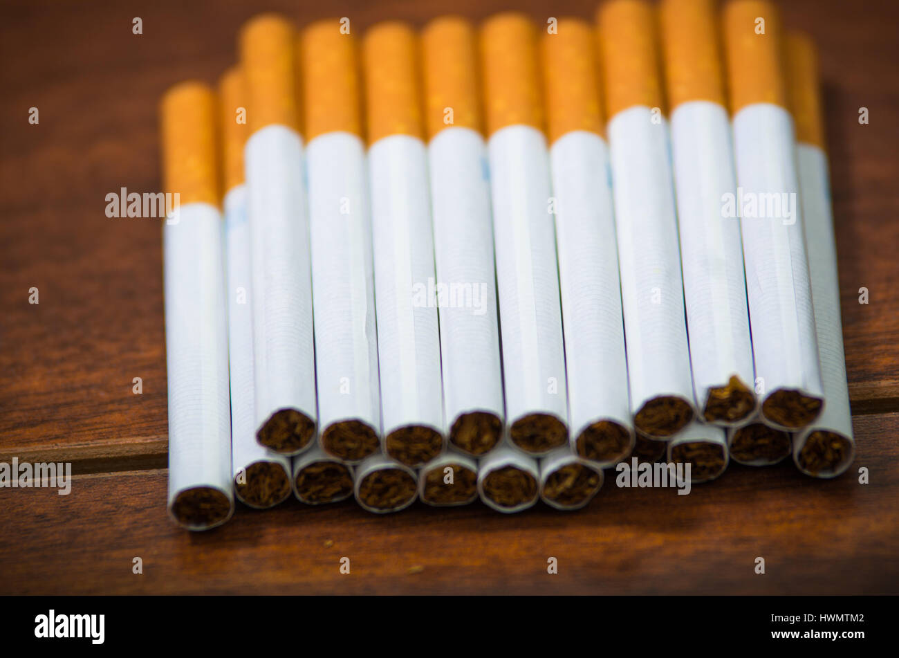 Stack of many cigarettes placed on wooden surface, as seen from above ...