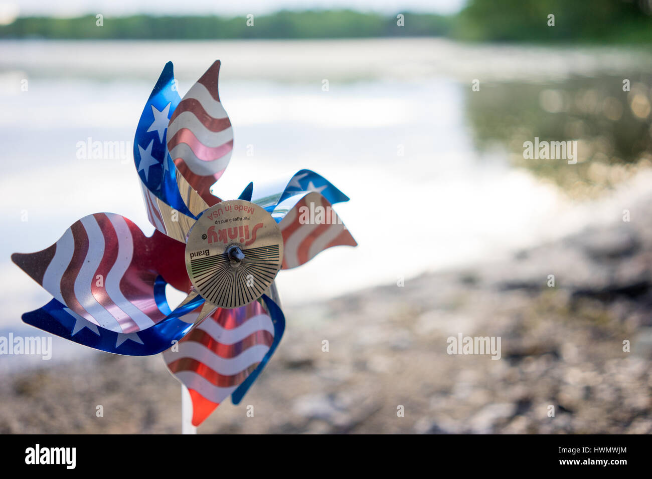 An American flag pin wheel sits in the mud on the lake front Stock ...