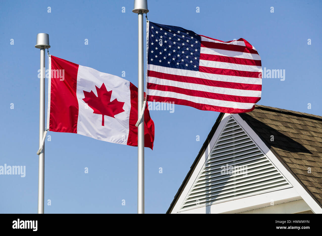 An American flag and a Canadian flag flying side by side Stock Photo ...