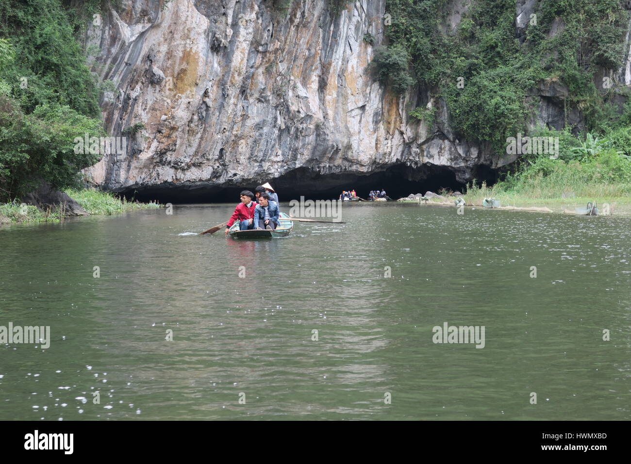 A view from a boat. Rowing with the feet on the Tam Coc River in Ninh ...