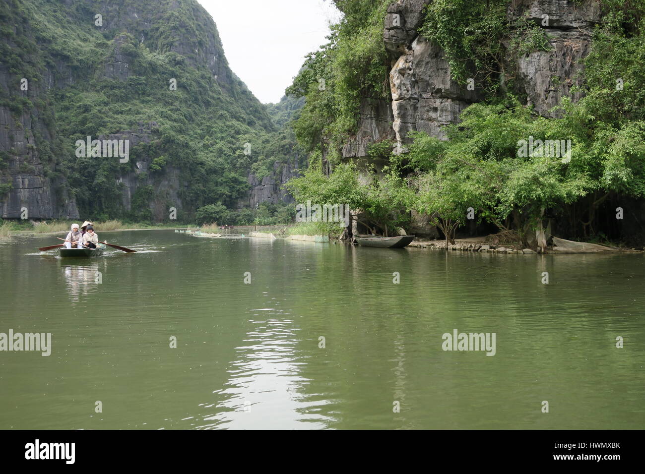 A view from a boat. Rowing with the feet on the Tam Coc River in Ninh ...