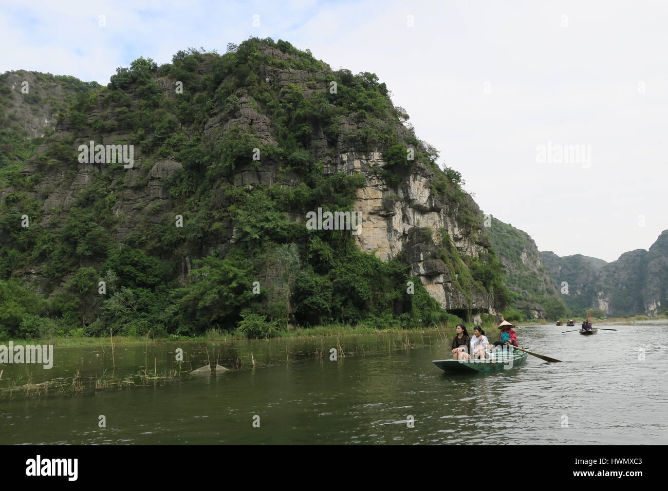 A view from a boat. Rowing with the feet on the Tam Coc River in Ninh ...