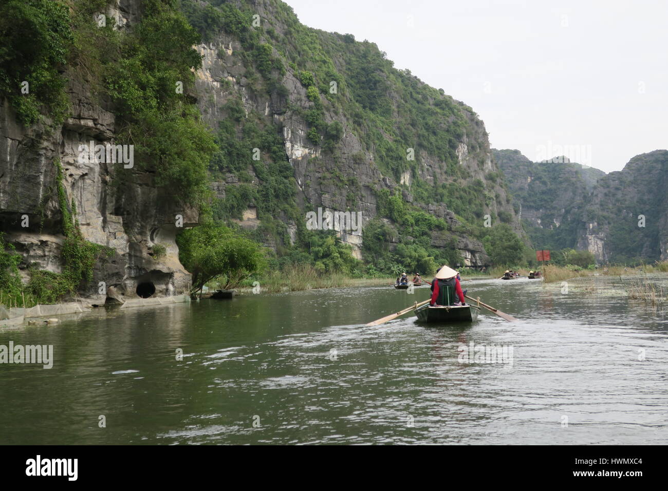 A view from a boat. Rowing with the feet on the Tam Coc River in Ninh ...