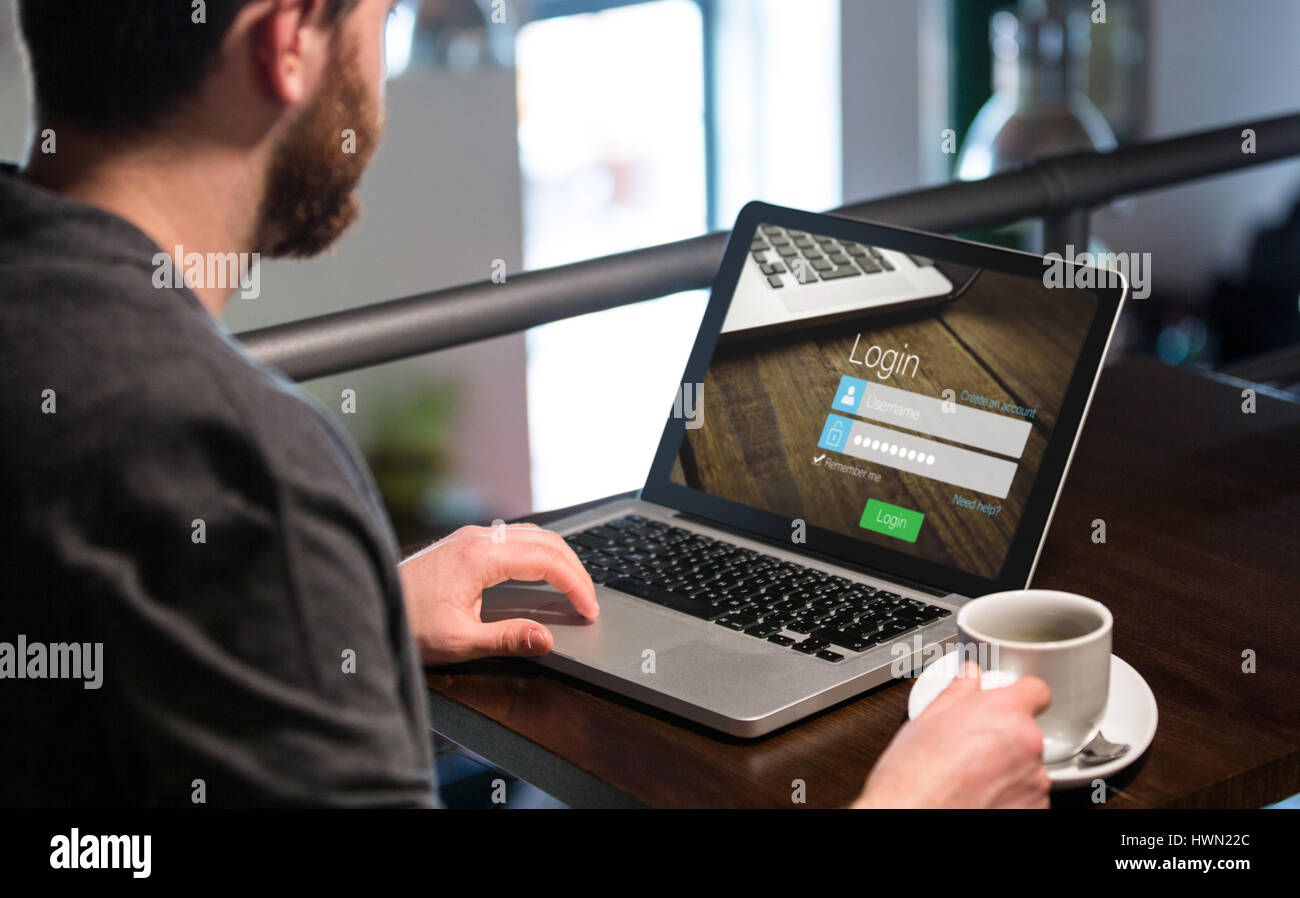 Close-up of login page against man holding coffee cup and using laptop ...