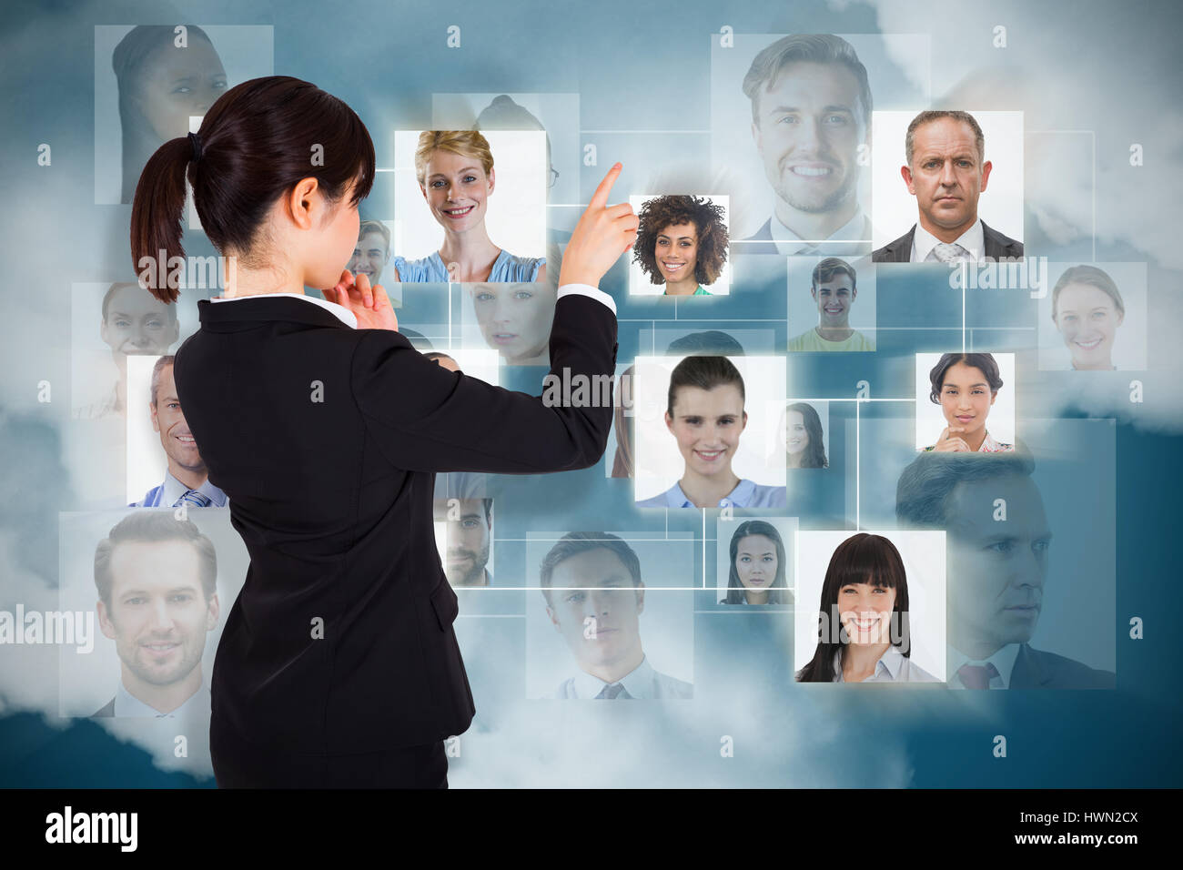 Thoughtful businesswoman pointing against dark blue background Stock ...