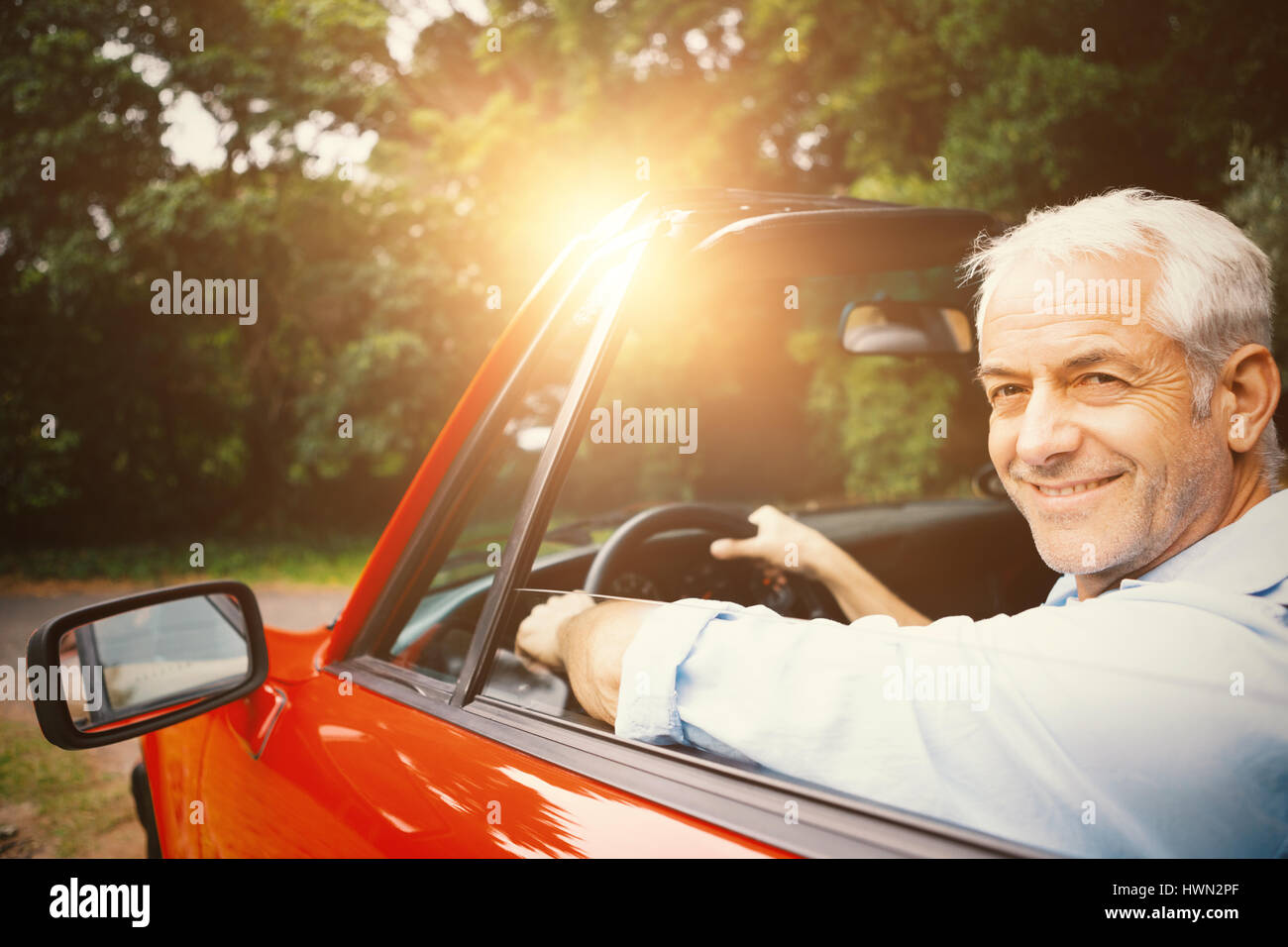 Smiling happy handsome man driving red car Stock Photo - Alamy