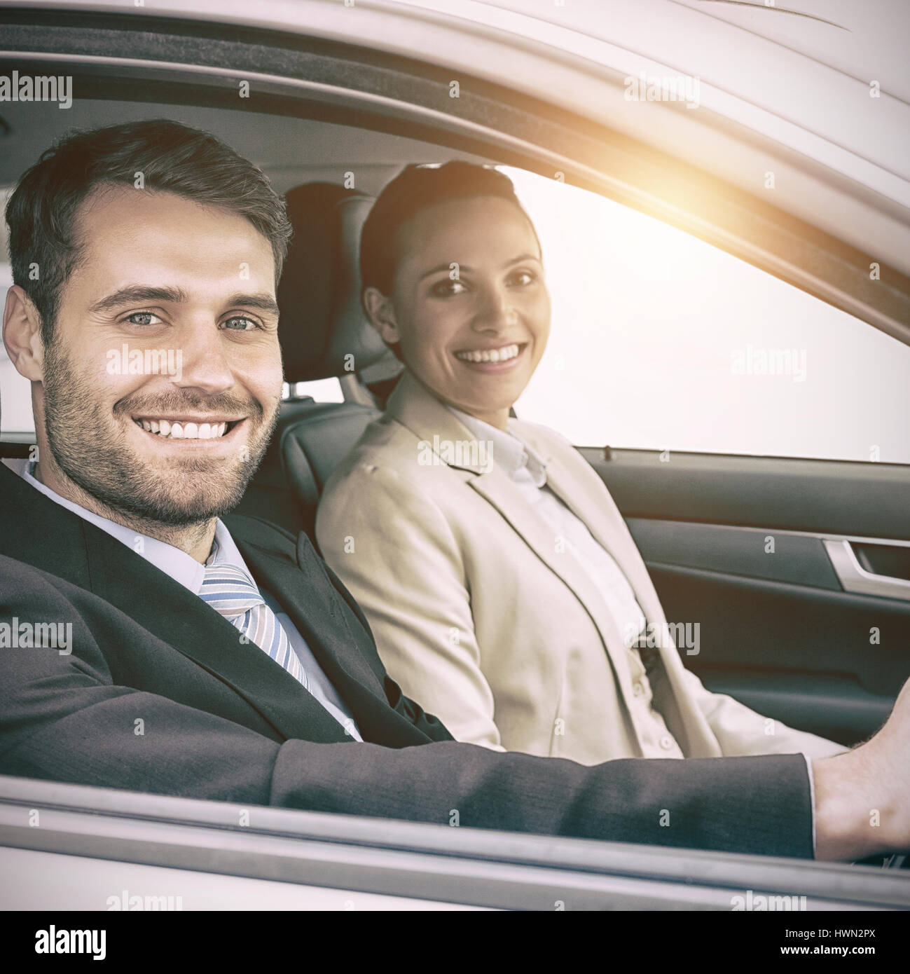 Couple in a car looking at the camera Stock Photo - Alamy
