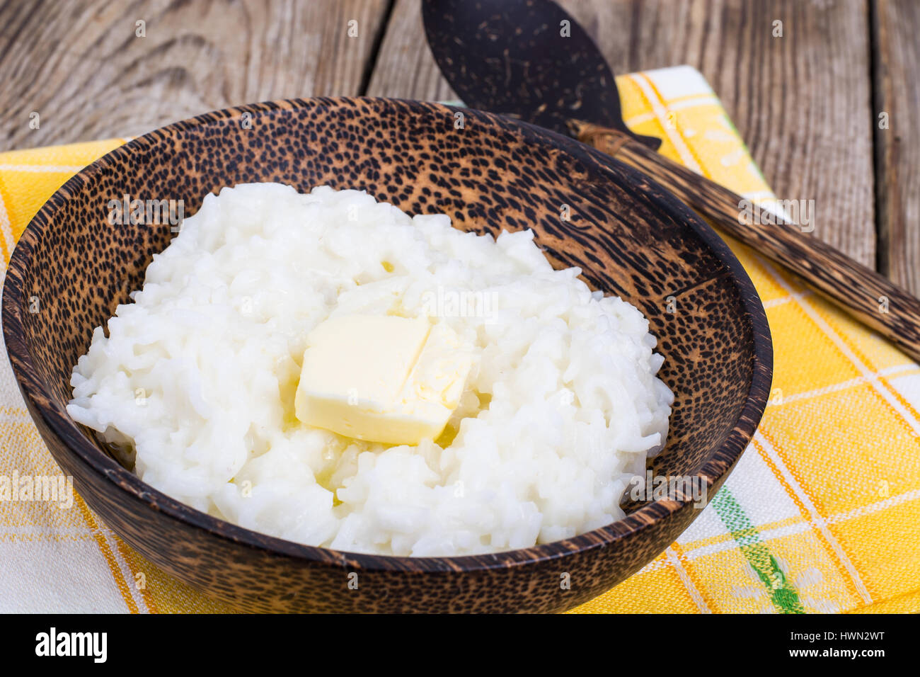 Milk rice porridge with butter in wooden bowl Stock Photo - Alamy