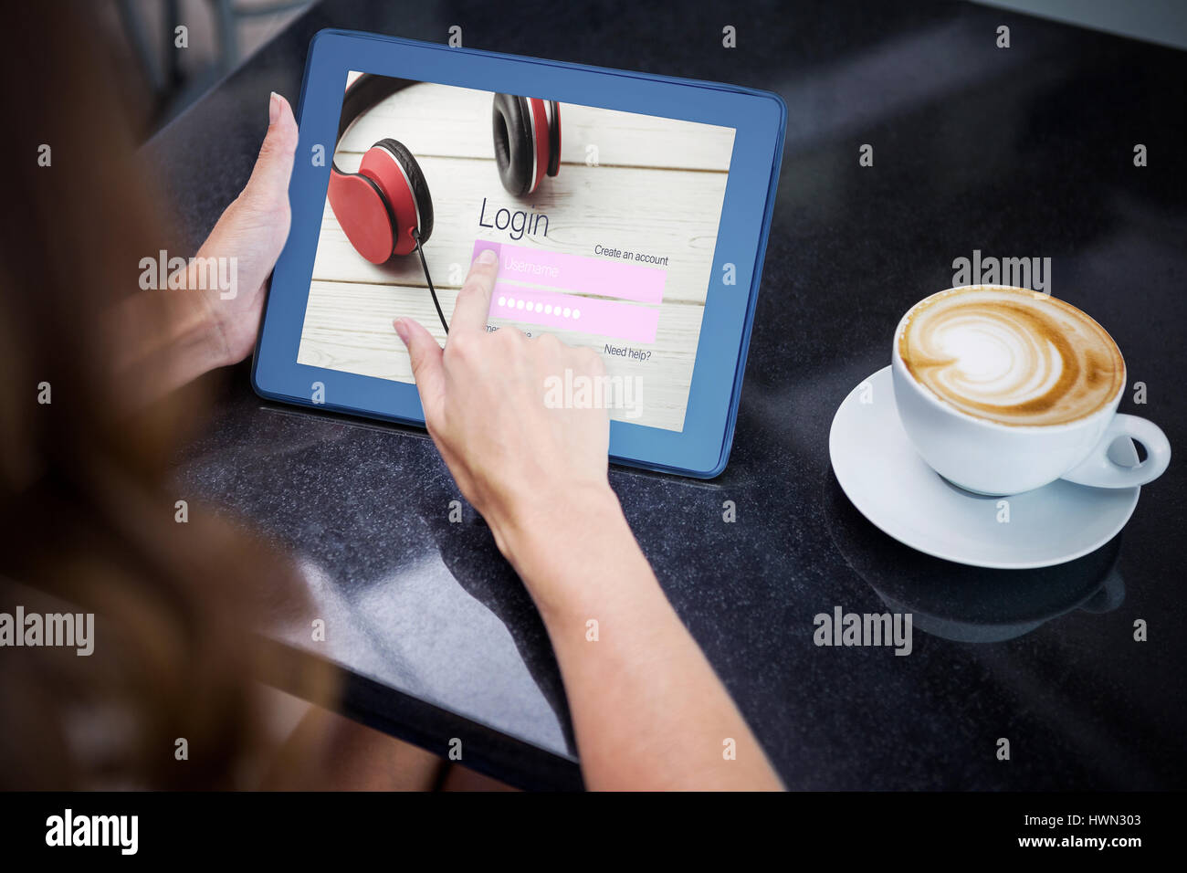 Close-up of login page against woman having coffee and using her tablet ...