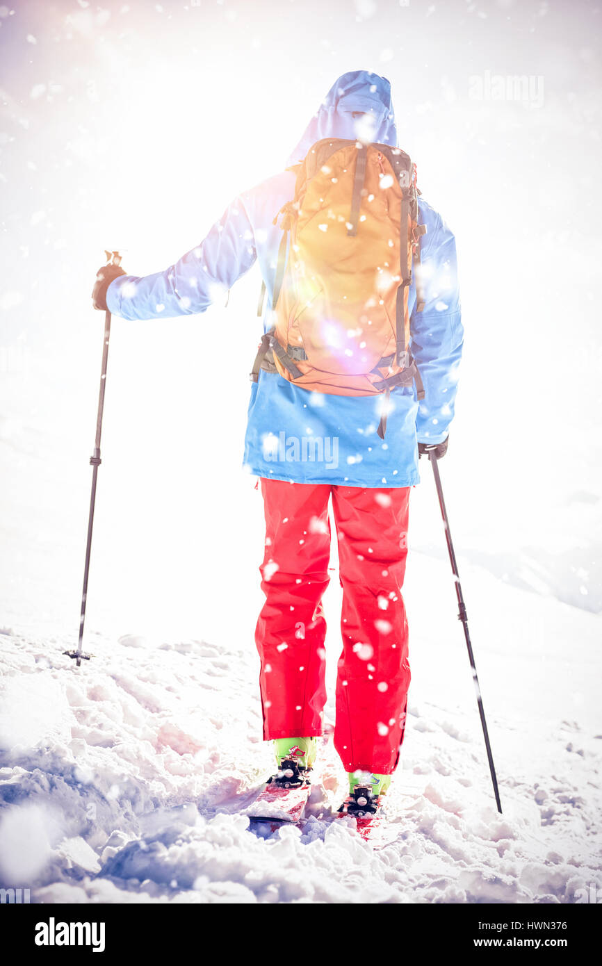 Full length rear view of skier walking on the slope with ski Stock ...