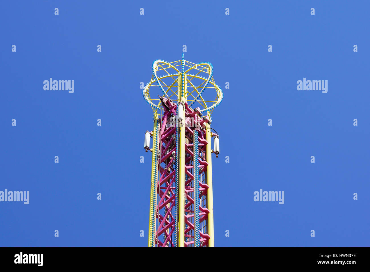 large flying carousel ride machine turning against the blue sky in a ...