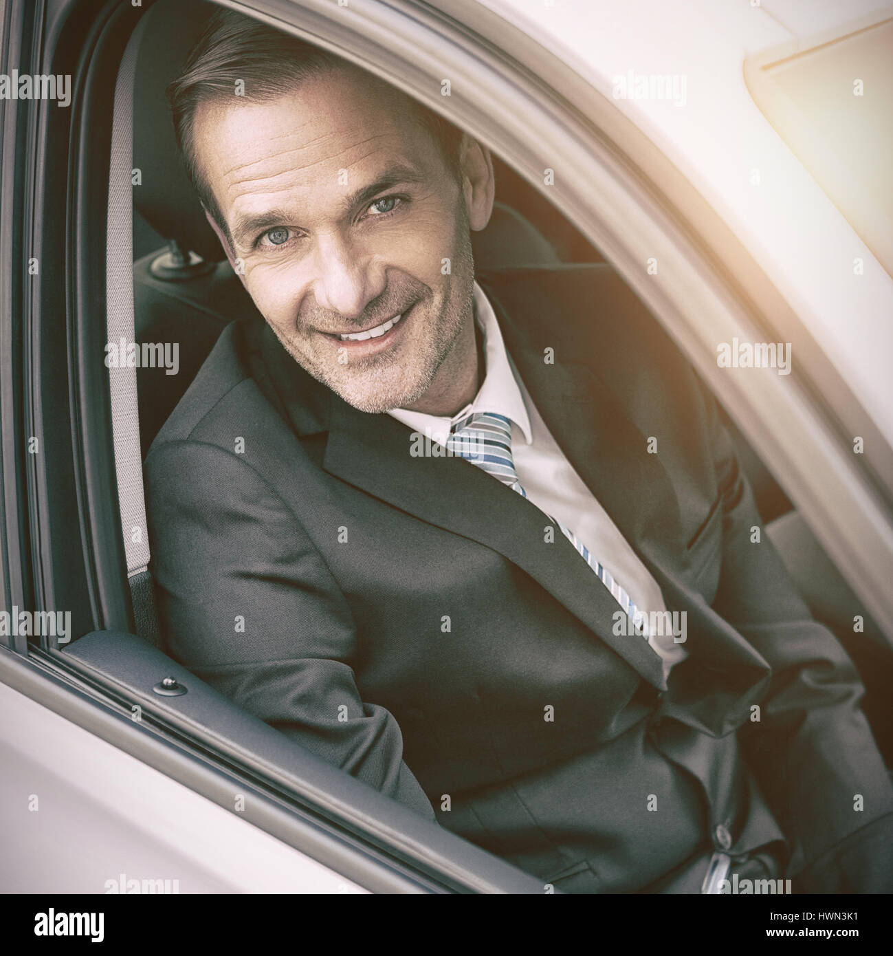Man sitting in a car looking at camera Stock Photo - Alamy