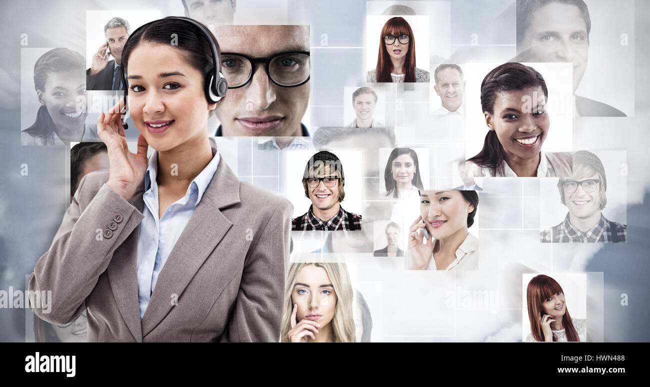 Portrait of a good looking operator posing with a headset against grey ...