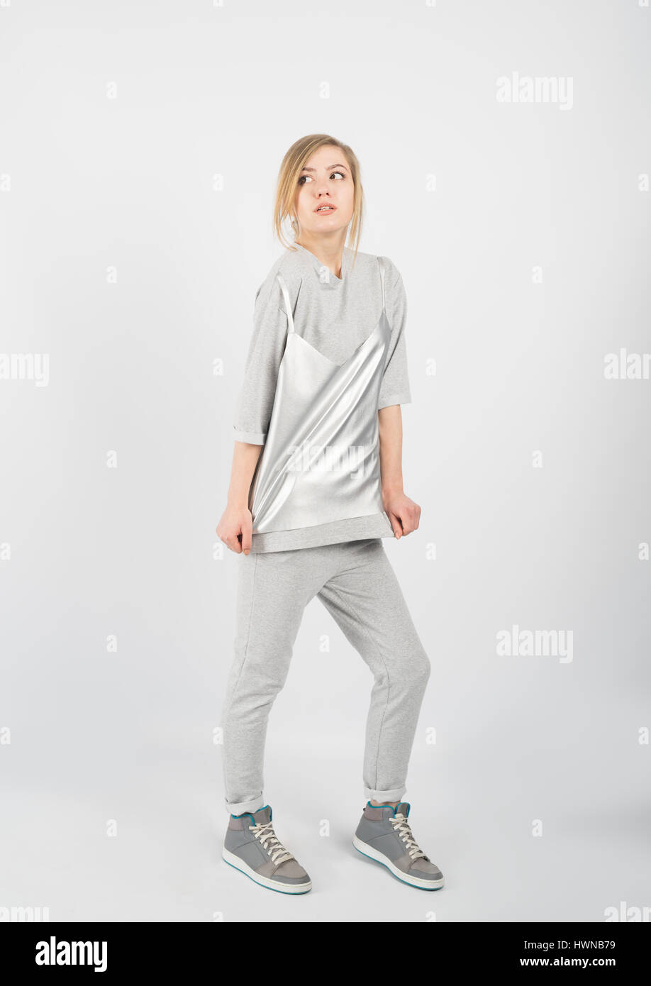 Young hipster girl wearing grey casual clothes and sneakers posing ...