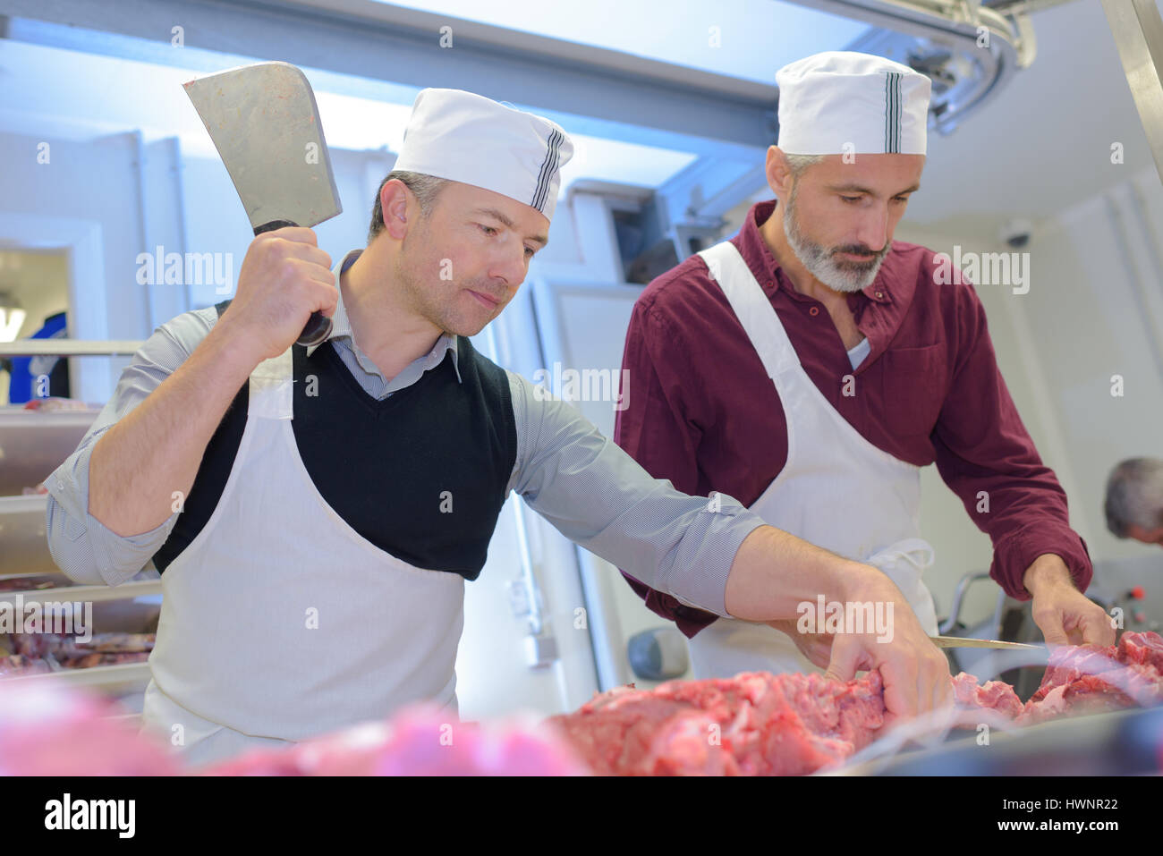 Butcher with raised machete to chop meat Stock Photo - Alamy