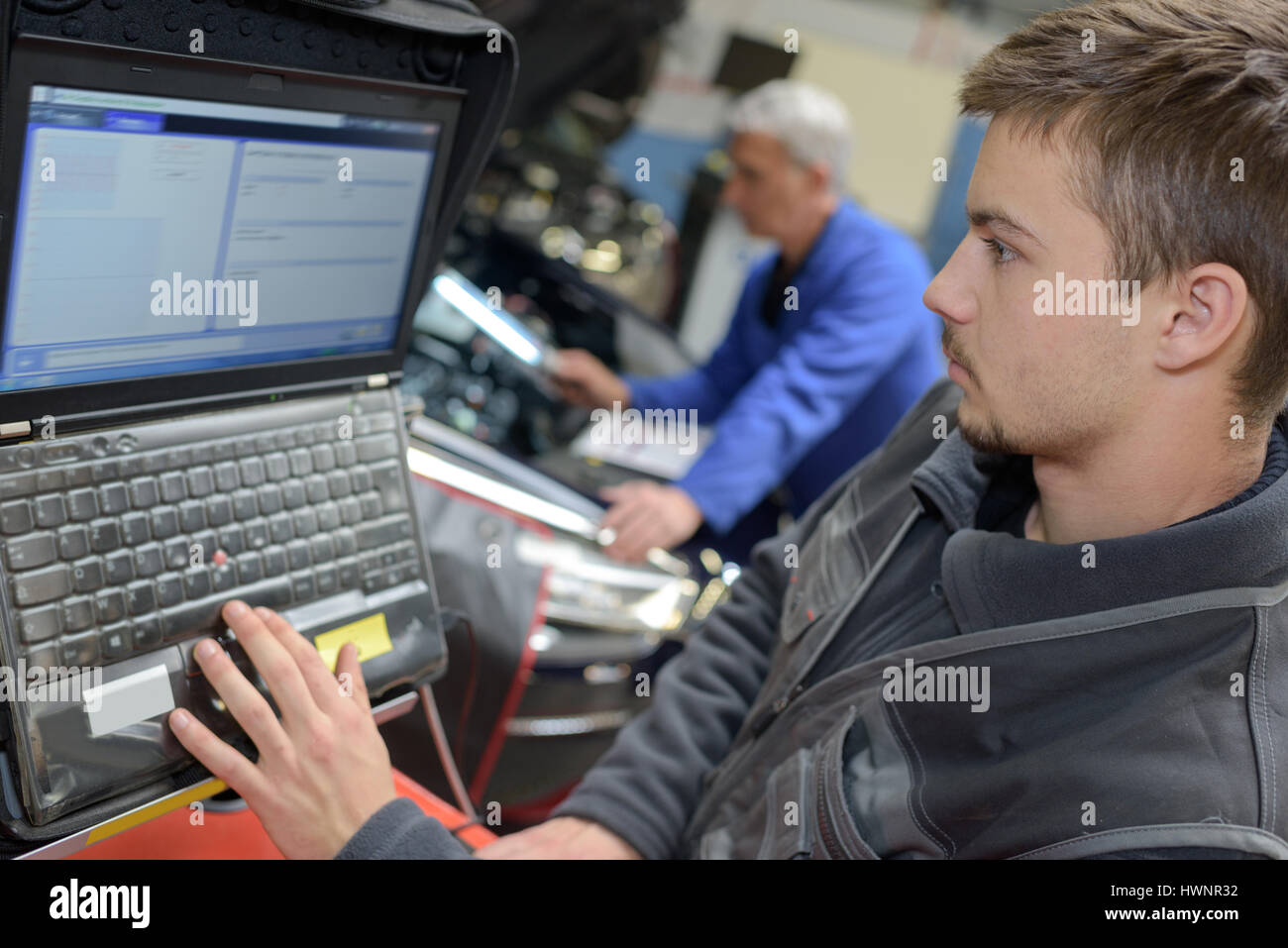 car mechanic analyzing car electronic in auto repair service Stock ...
