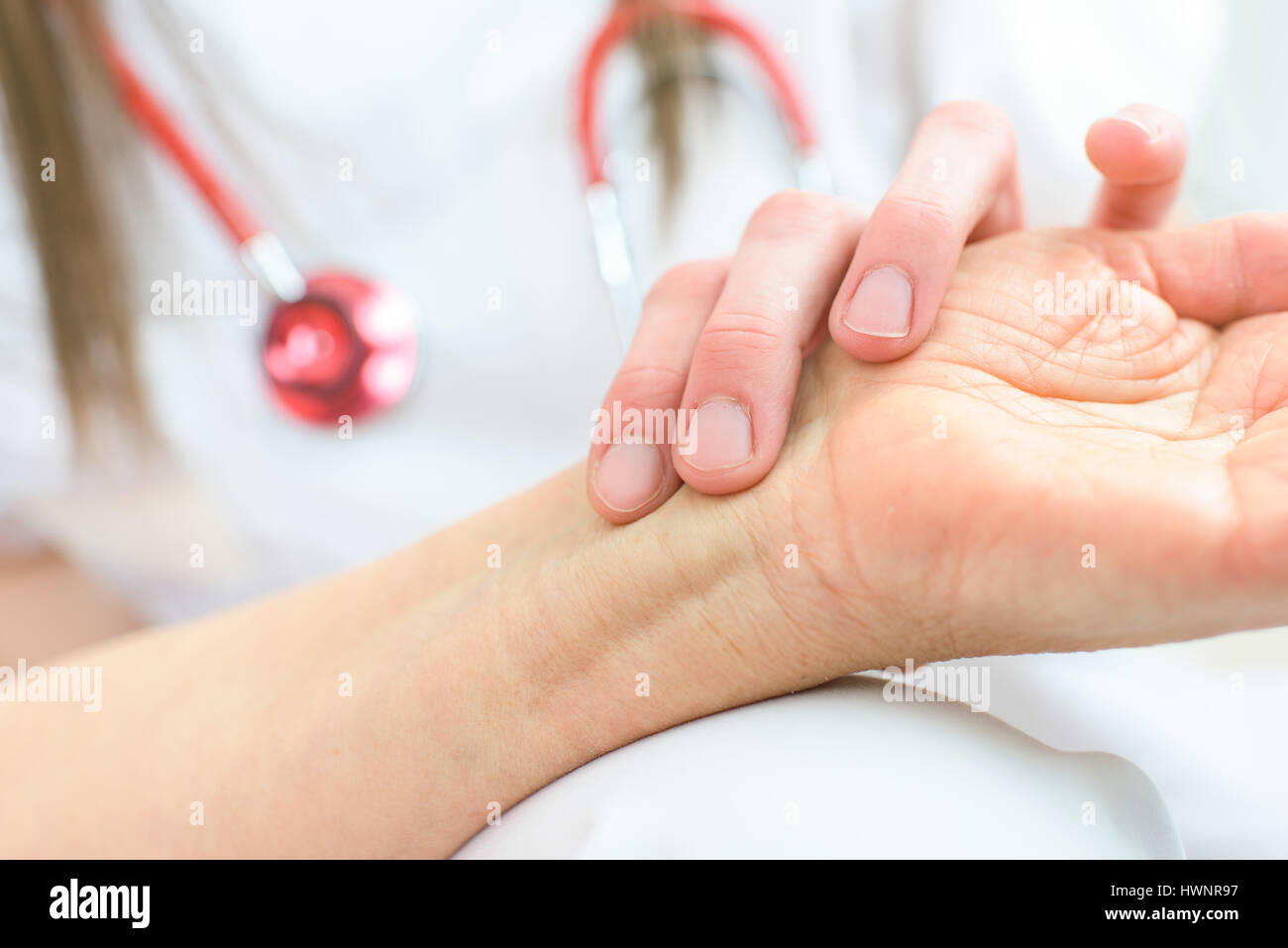Checking a patient's pulse Stock Photo - Alamy