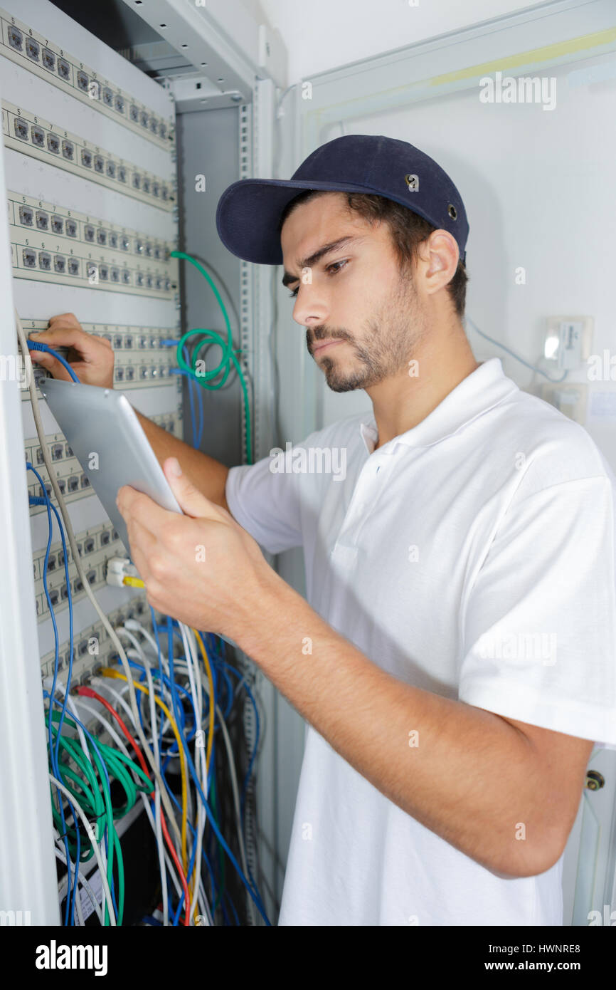 focused electrician applying safety procedure while working on ...