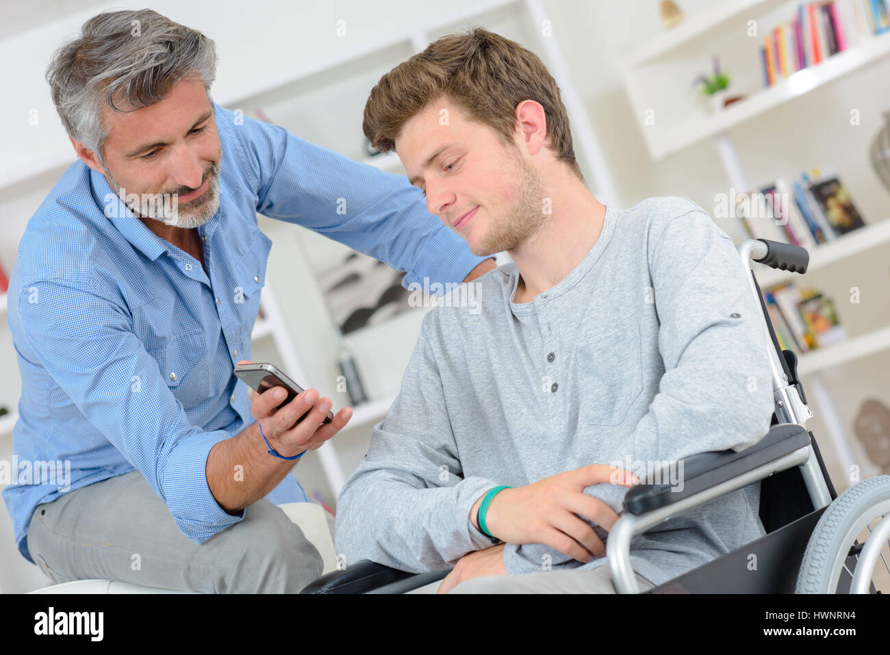 man showing a message to a young man Stock Photo - Alamy