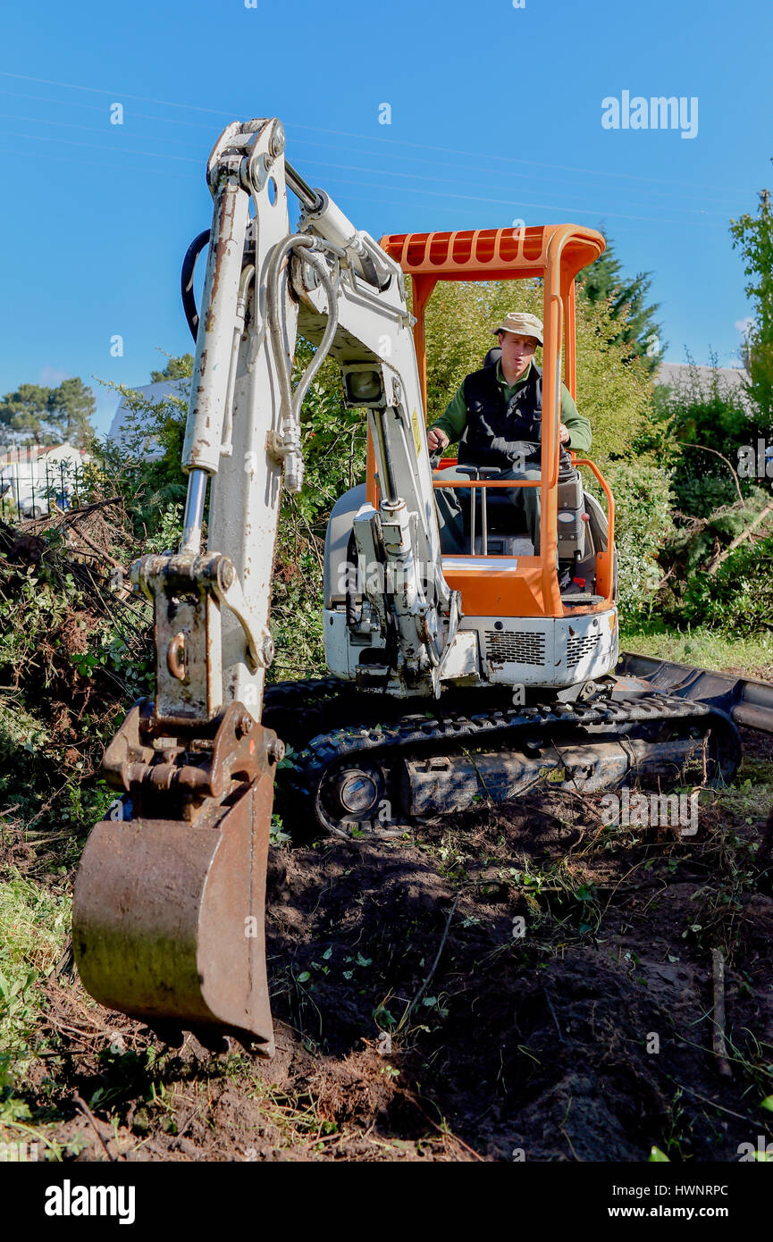 Man using a digger in the garden Stock Photo - Alamy