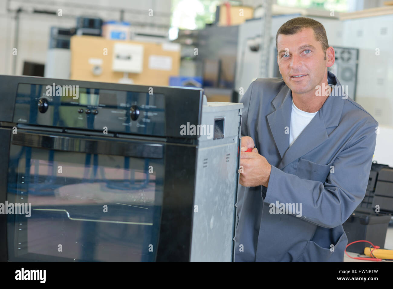 Repairman working on oven Stock Photo - Alamy