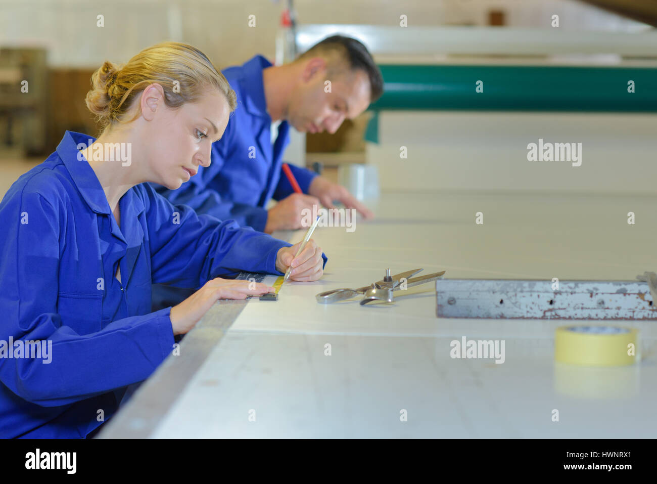 Workers marking position to cut material Stock Photo - Alamy