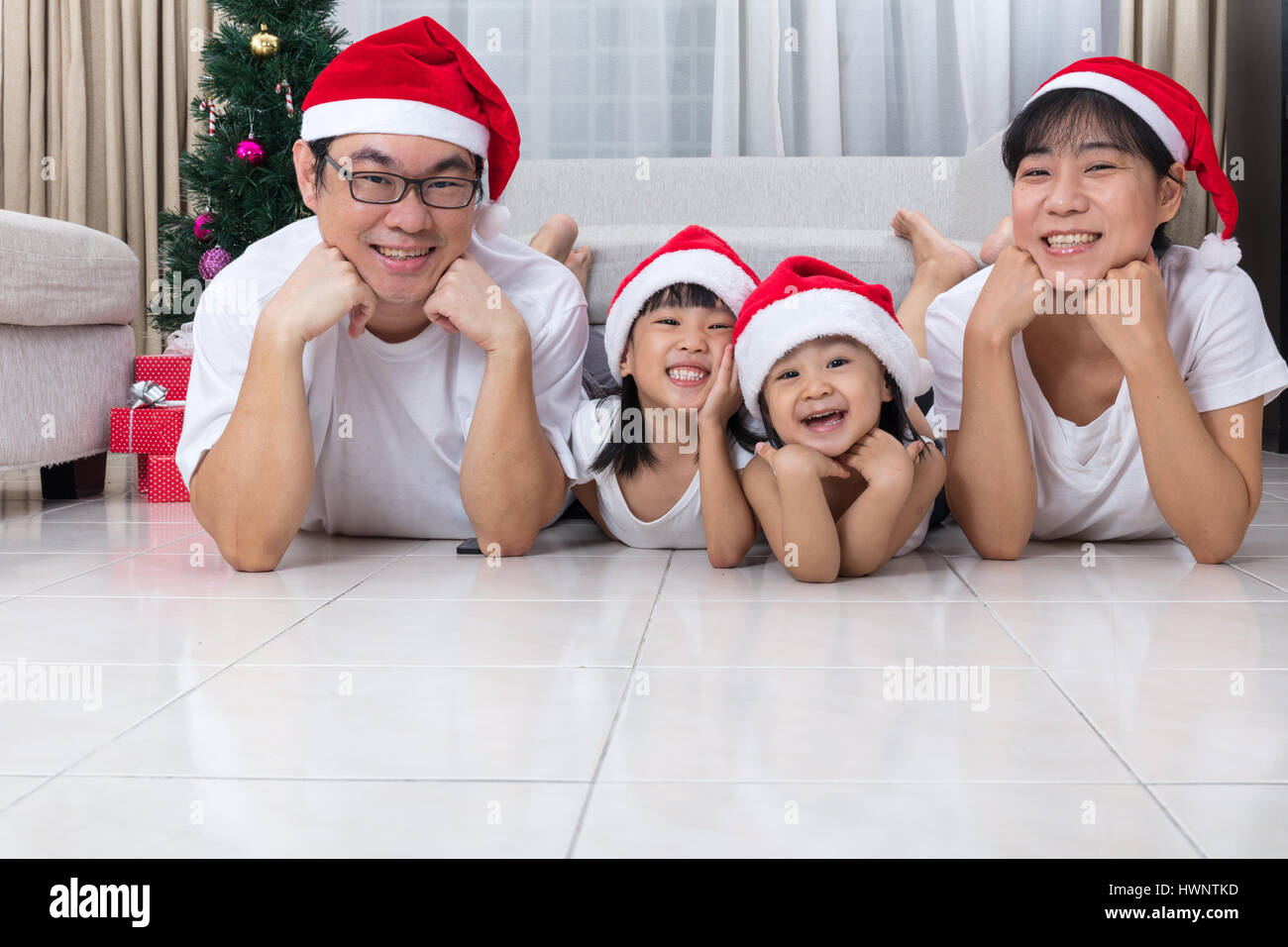 Happy Asian Chinese family lying on the floor celebrating Christmas in ...