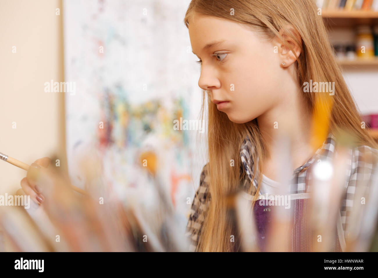 Finding my painting style. Concentrated charming skillful girl sitting ...