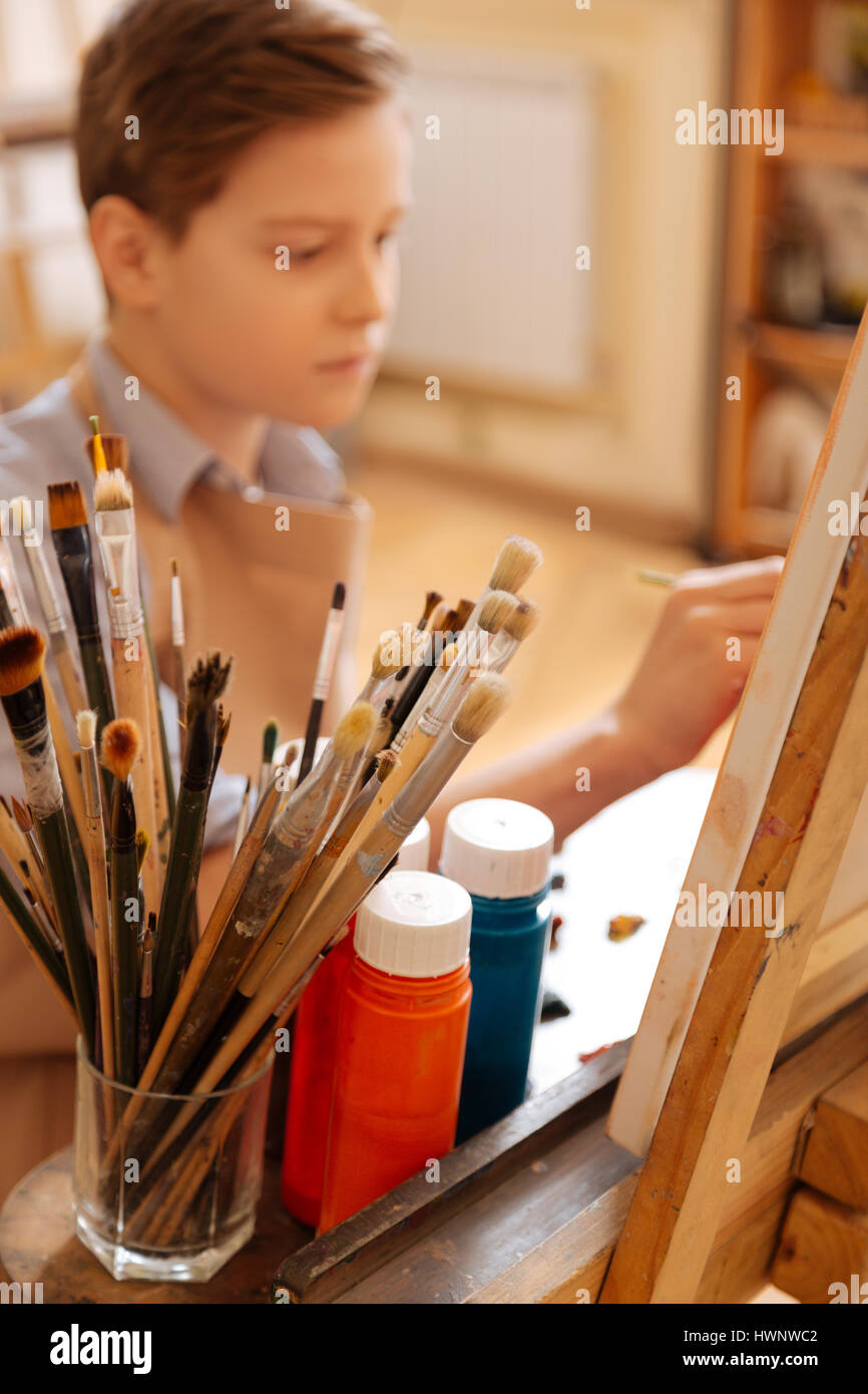 My first art class. Concentrated inspired positive child sitting at ...