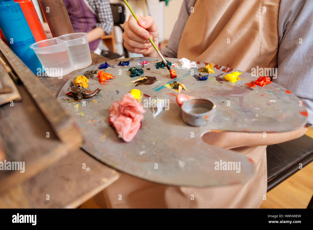 Mixing colors . Pleasant skillful gifted child sitting at school and ...