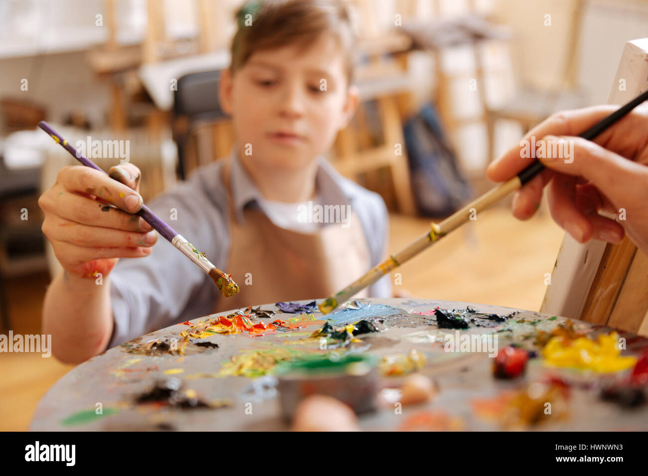 Using colorful pallet . Proficient skillful helpful artist standing in ...
