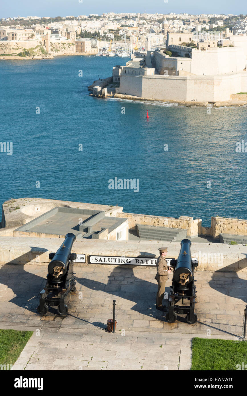 A soldier in uniform preparing to fire a canon at the saluting battery ...