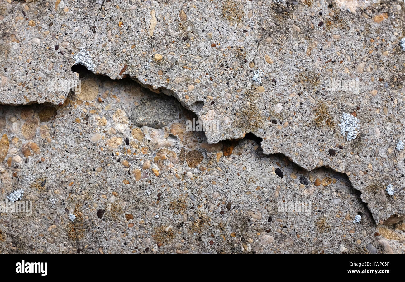 Chipped and broken smooth concrete surface with a jagged diagonal line ...