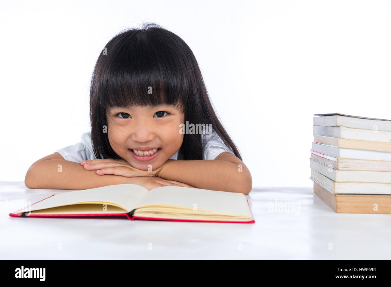 Smiling Asian Chinese little girl reading book in isolated white ...
