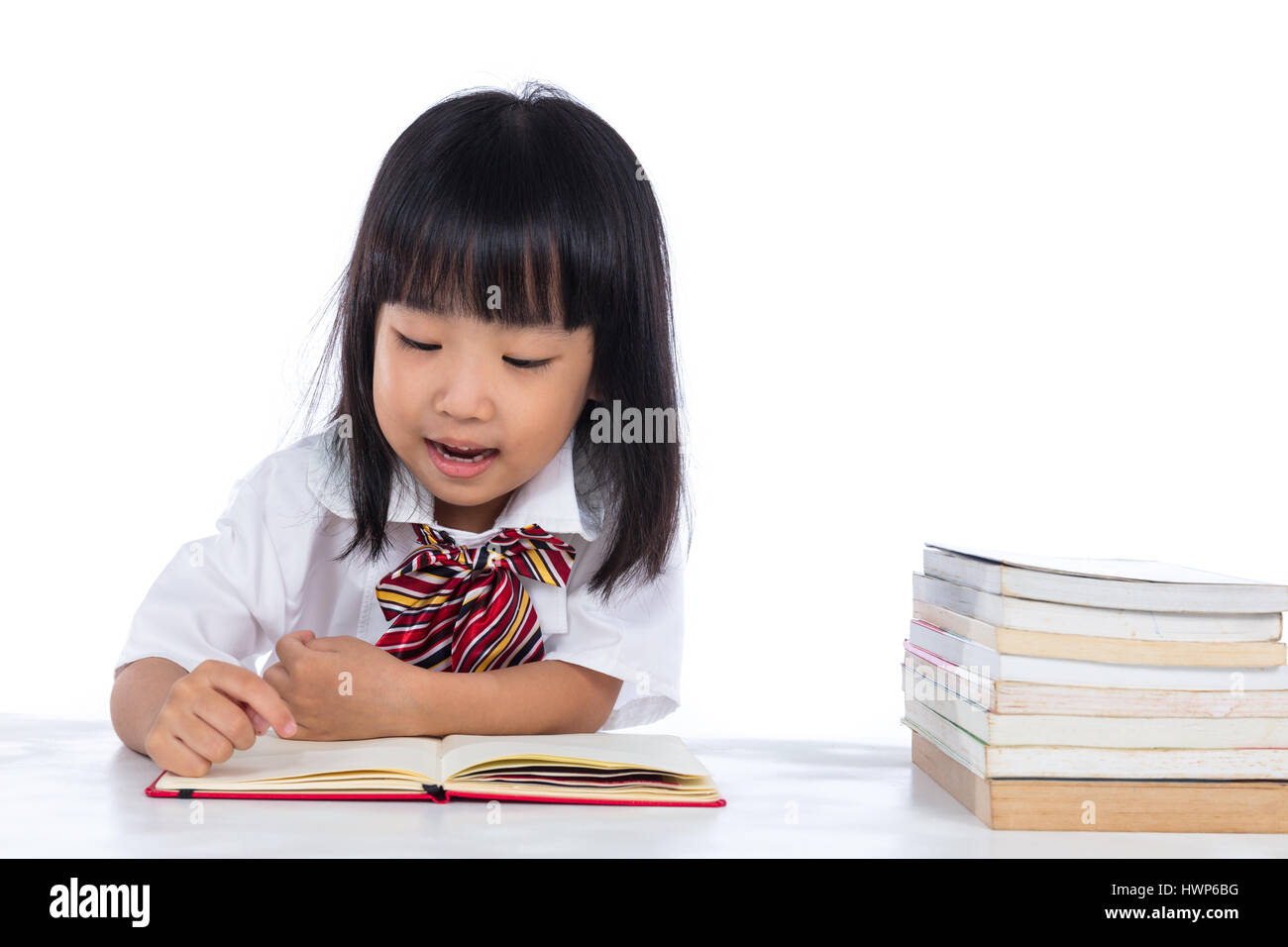 Happy Asian Chinese little girl reading book in isolated white ...
