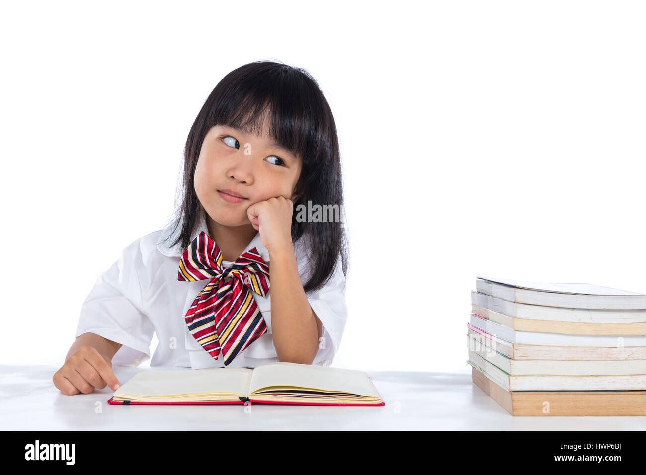 Asian Chinese little girl thinking while reading in isolated white ...