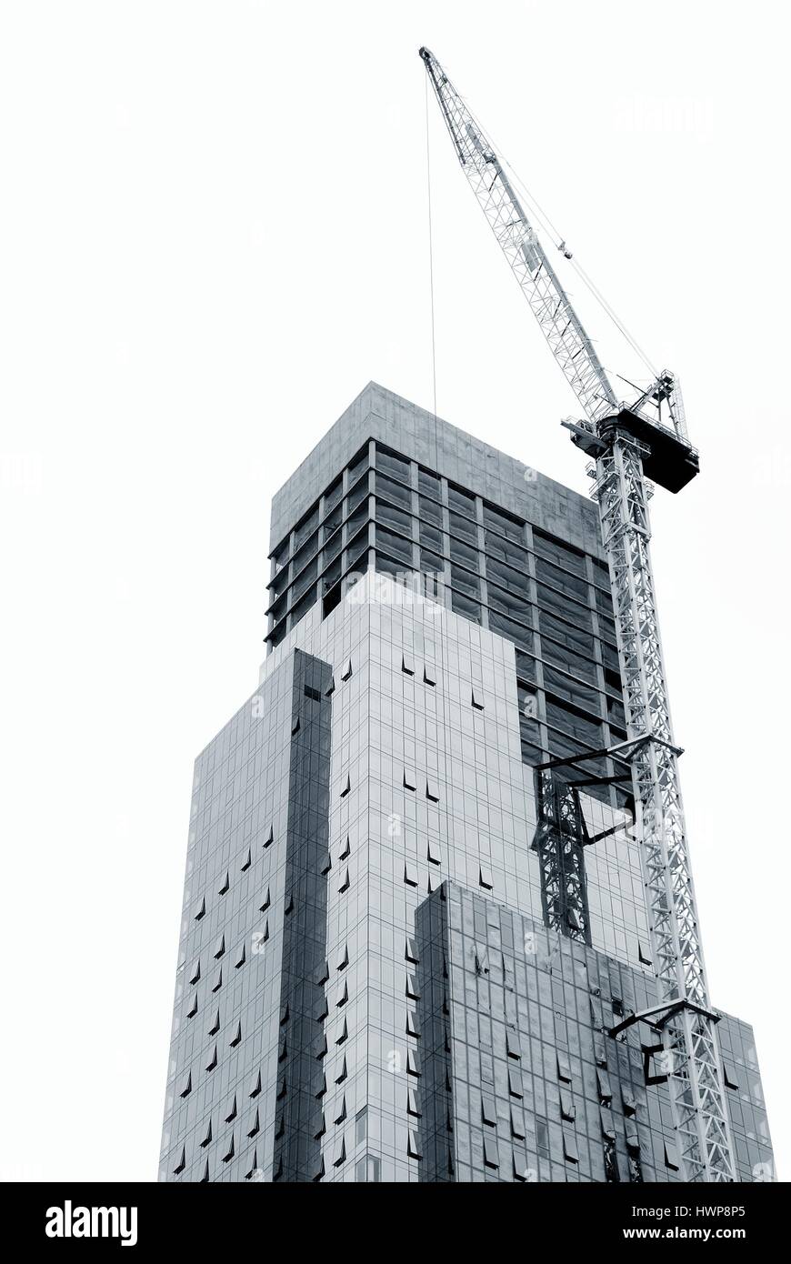 Skyscraper under construction with crane on white background ...