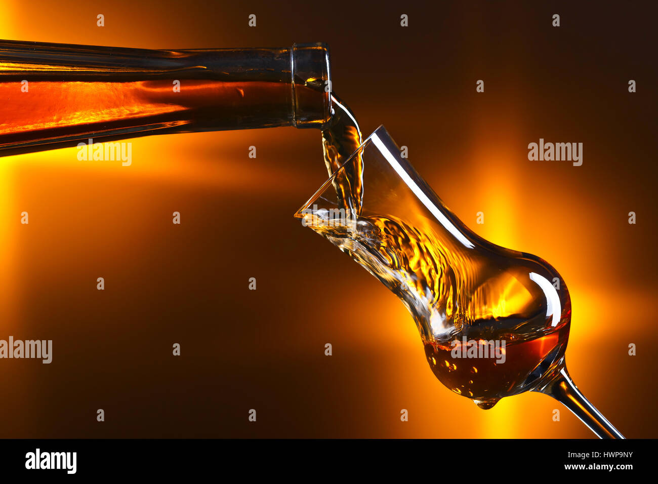 Pouring alcohol into a wineglass on dark background Stock Photo - Alamy