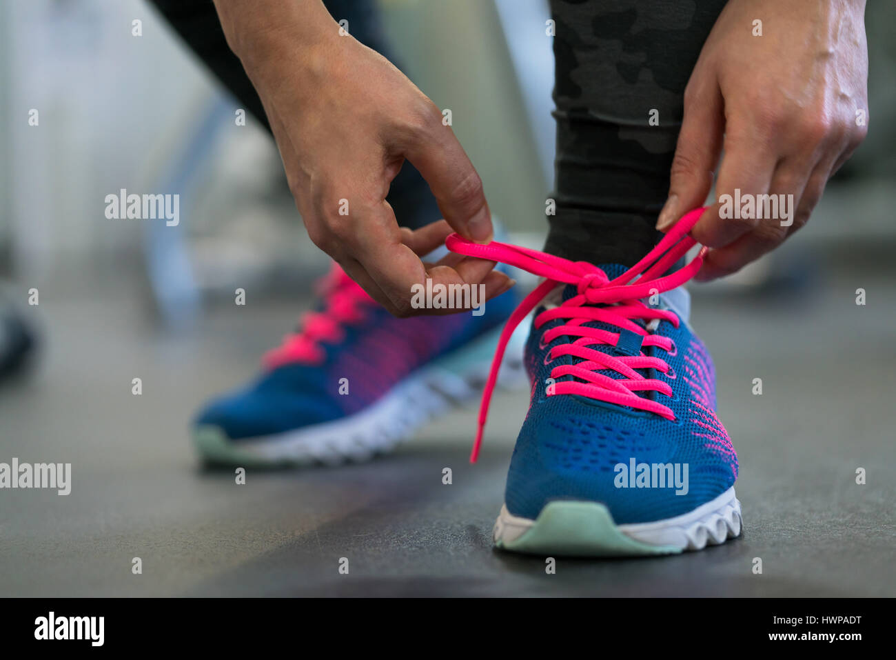 Running shoes - woman tying shoe laces. Closeup of fitness woman getting ready for engage in the ...