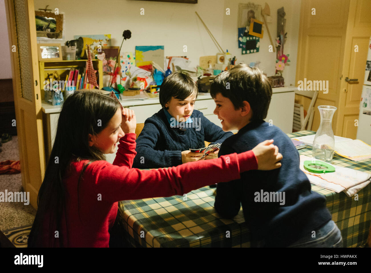 Children play cards at home at the kitchen table Stock Photo - Alamy