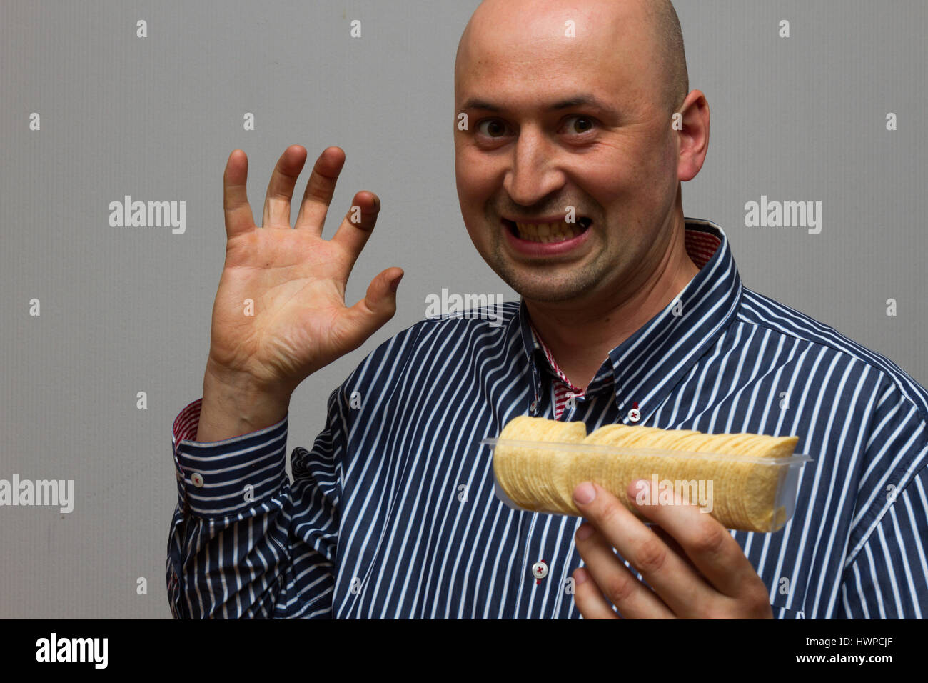 Joyful man holding a bag of potato chips Stock Photo - Alamy