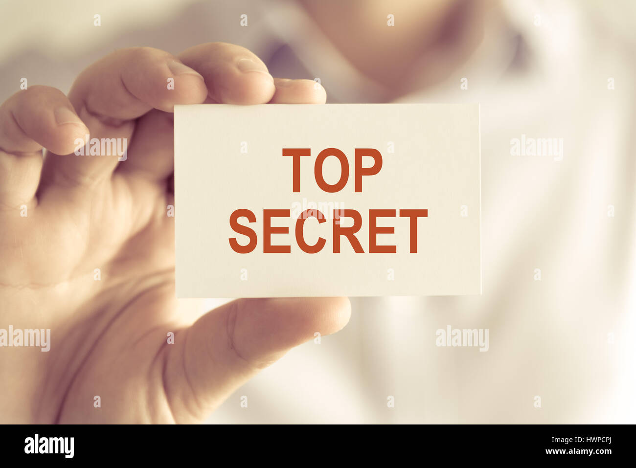 Closeup on businessman holding a card with text TOP SECRET, business ...