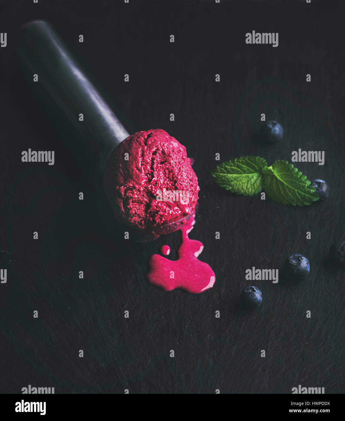Melting scoop of blueberry ice-cream with mint leaves Stock Photo - Alamy