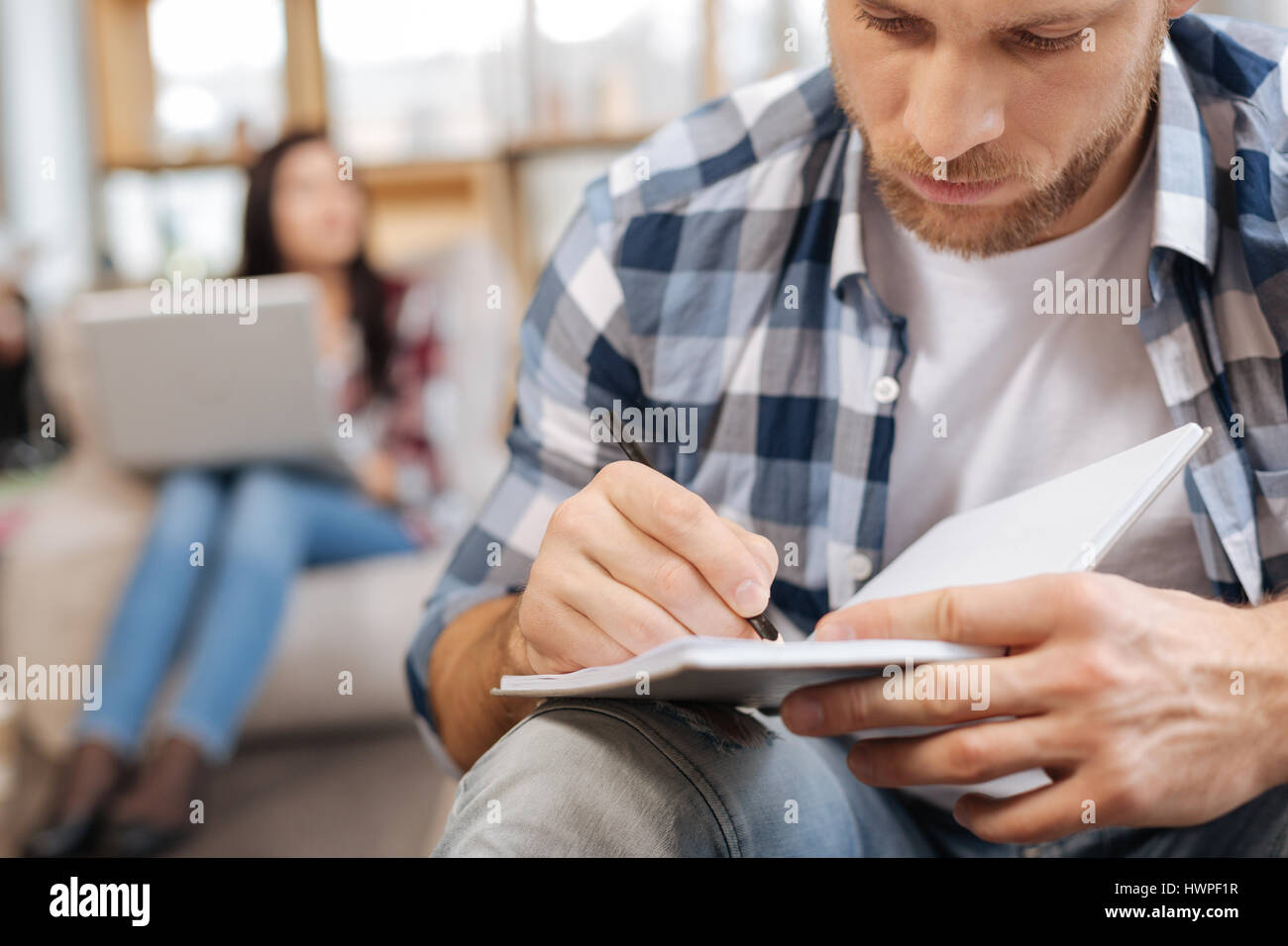 Serious concentrated man writing in the notebook Stock Photo - Alamy
